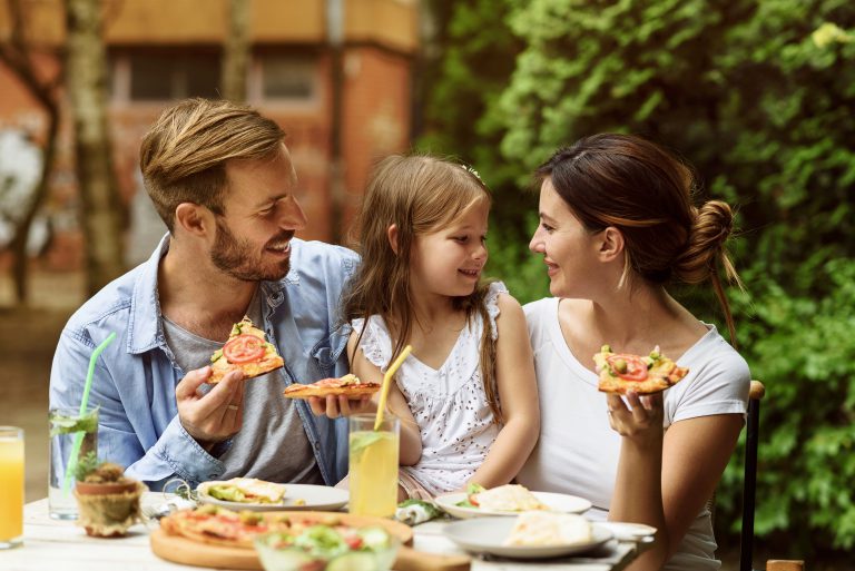 Happy family eating in a restaurant - The Shops at Hilltop